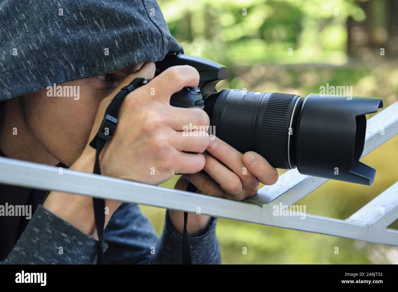 The photographer hidden with the camera. A man in a hood is taking ...