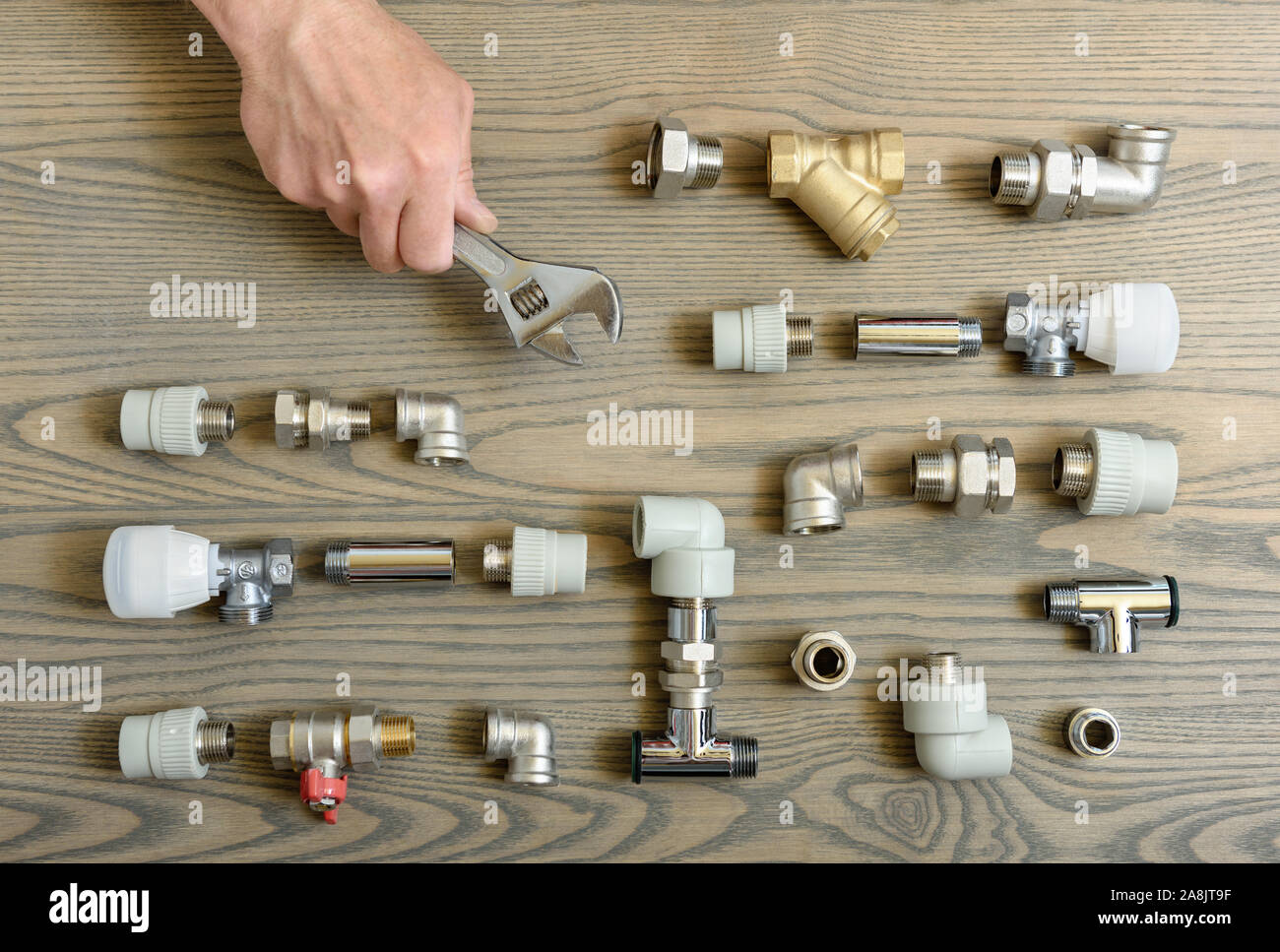 A human hand is holding the adjustable wrenches near elements of the ...