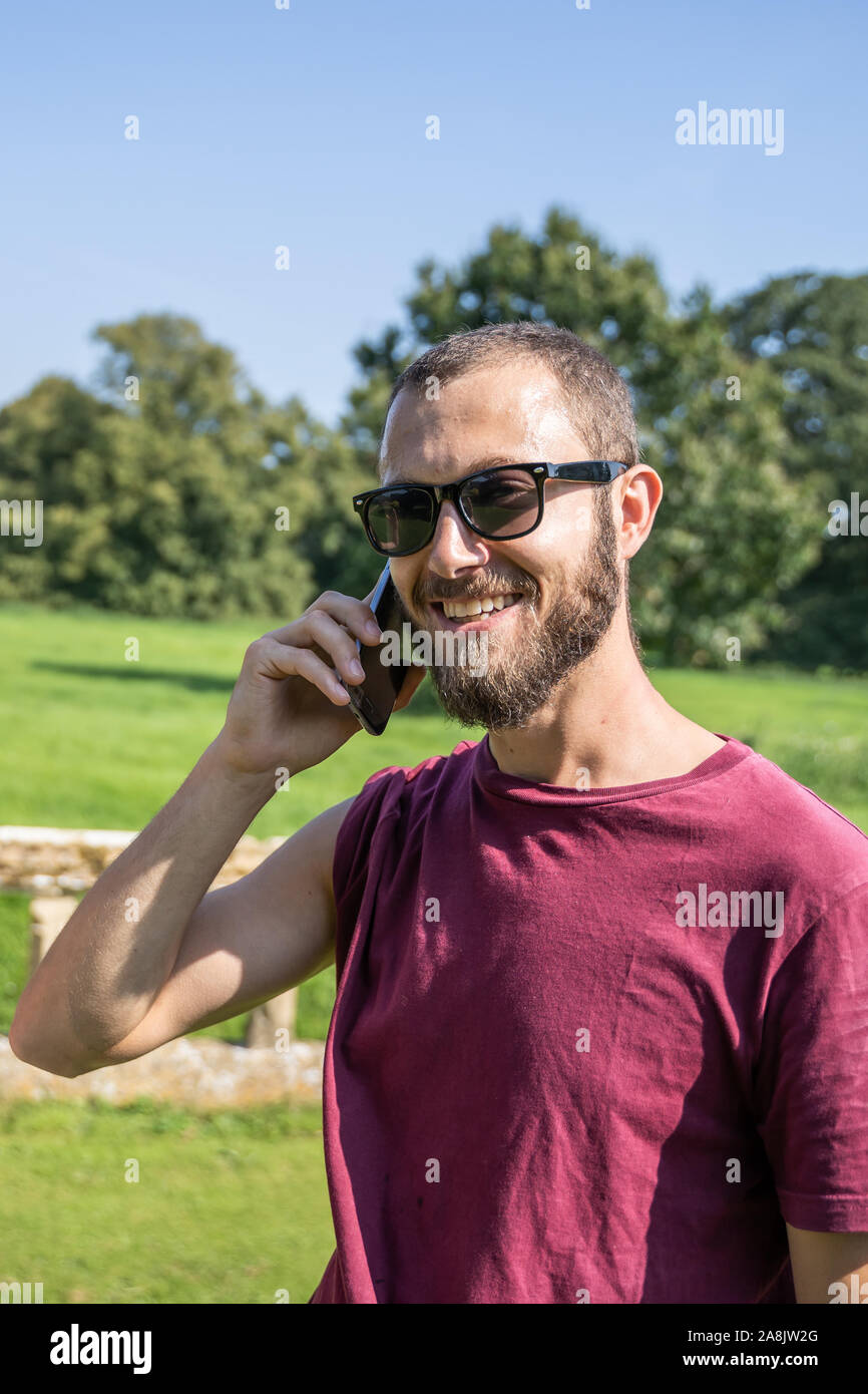 Stock vertical photo of a guy with sunglasses smiling and talking to ...