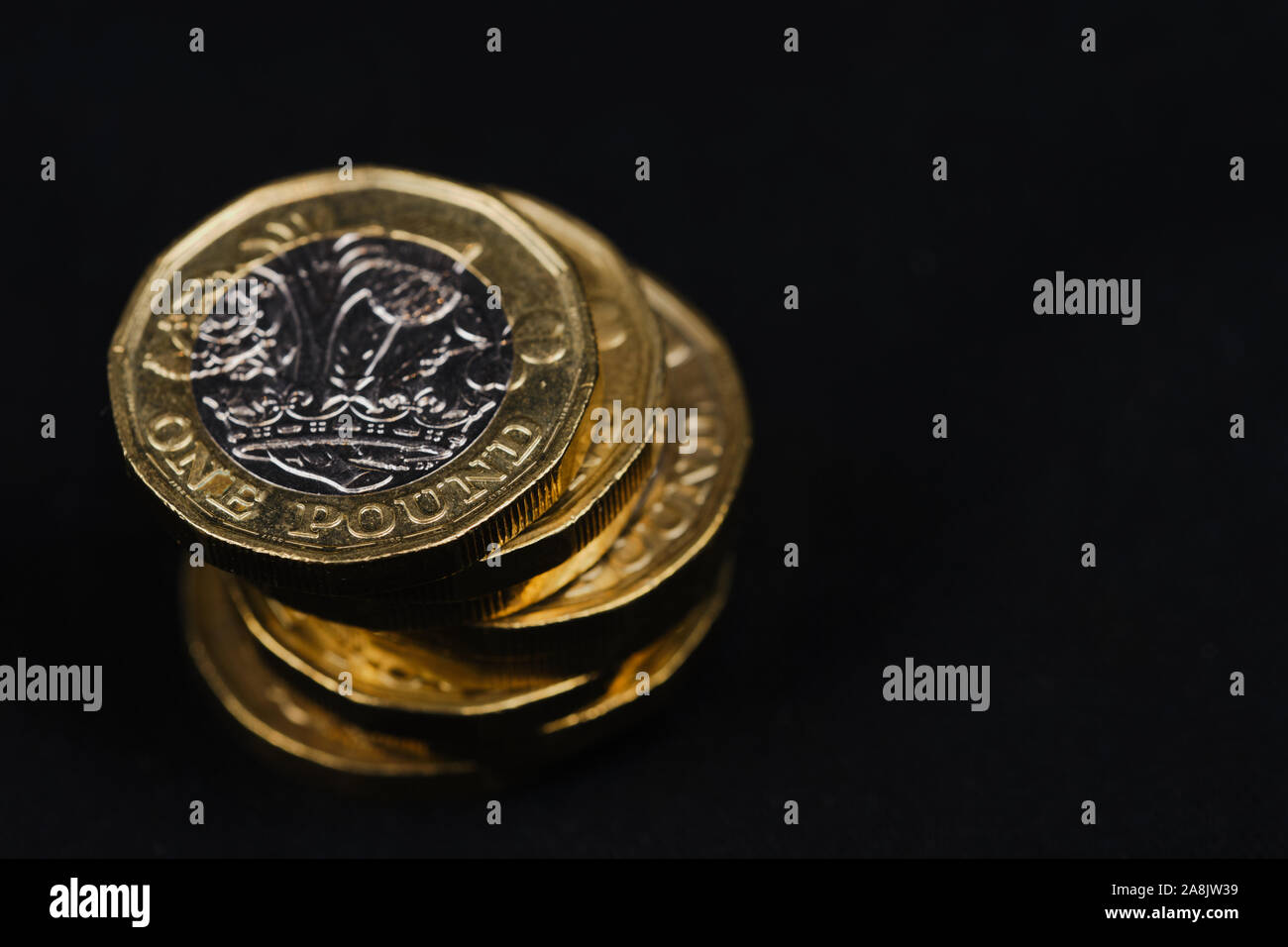 used British one pound coins against black background with copy space ...