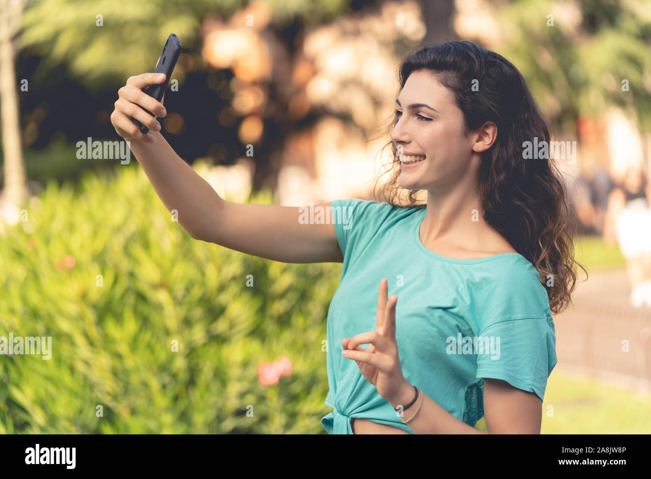 Portrait of laughing young woman taking selfie with smartphone hi-res ...