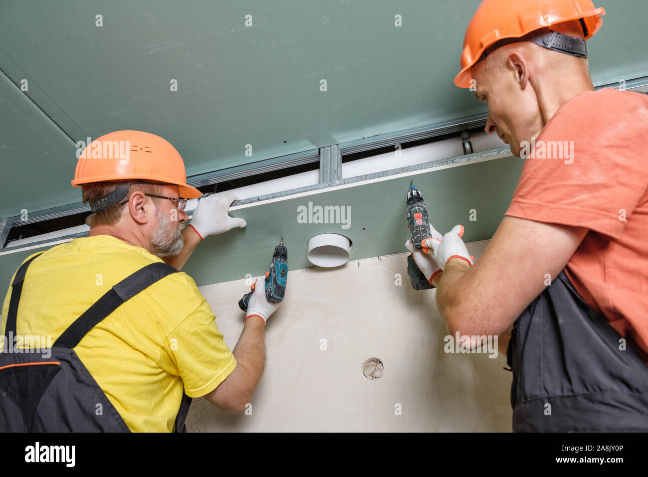 Installation of drywall. Workers are assembling the plasterboard with a ...