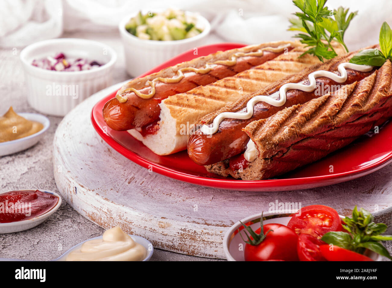 Hot dogs on red plate an sauses on white background. Fast food ...