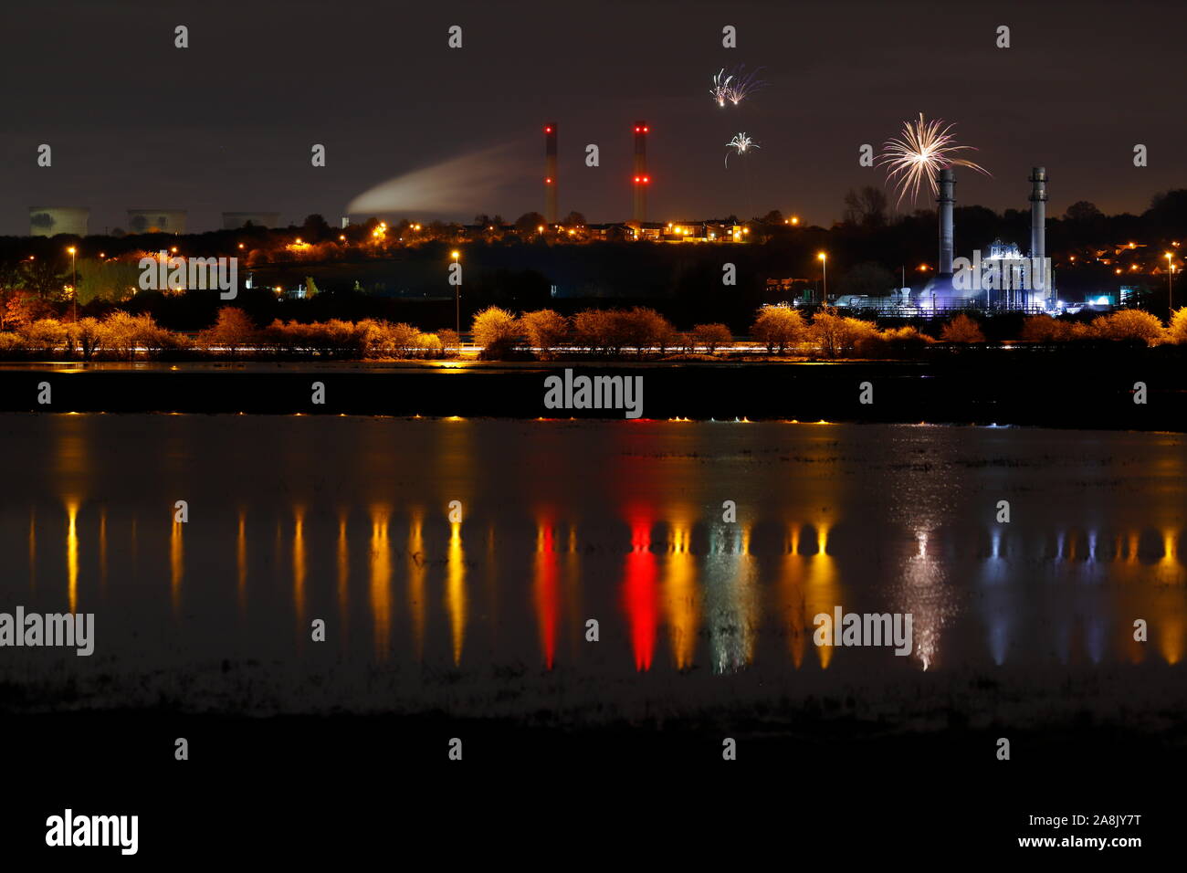 Reflections of Castleford at night in a flooded field. Cooling towers ...