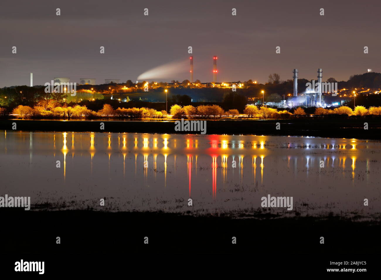 Reflections of Castleford at night in a flooded field. Cooling towers ...