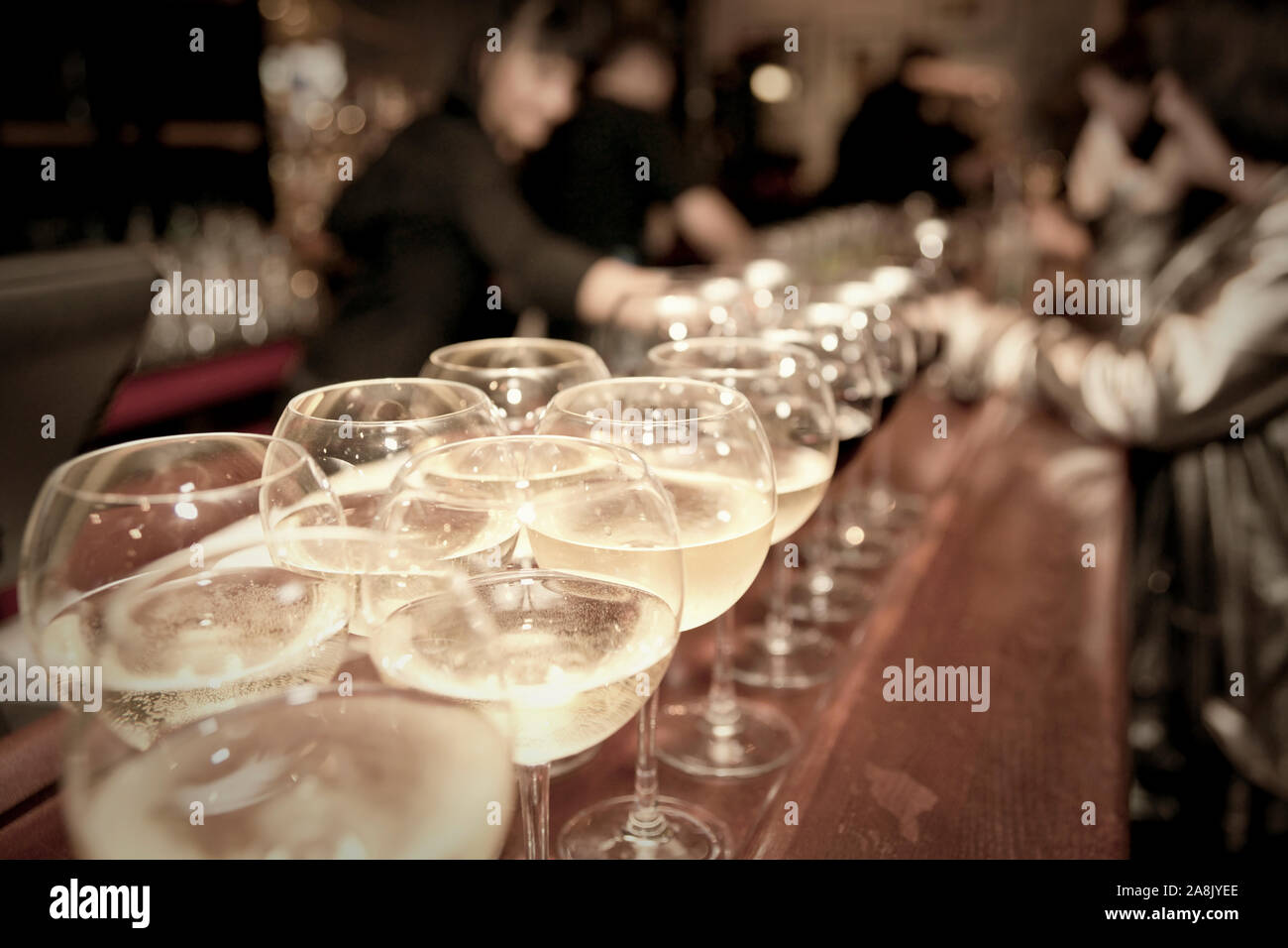 Wineglasses on bar counter with blurred crowd in background Stock Photo ...