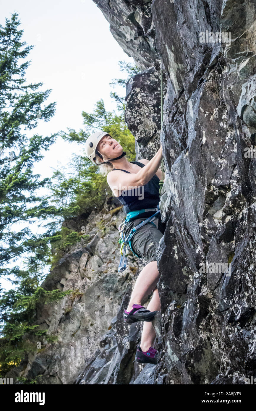 Woman rock climbing up cliff hi-res stock photography and images - Alamy