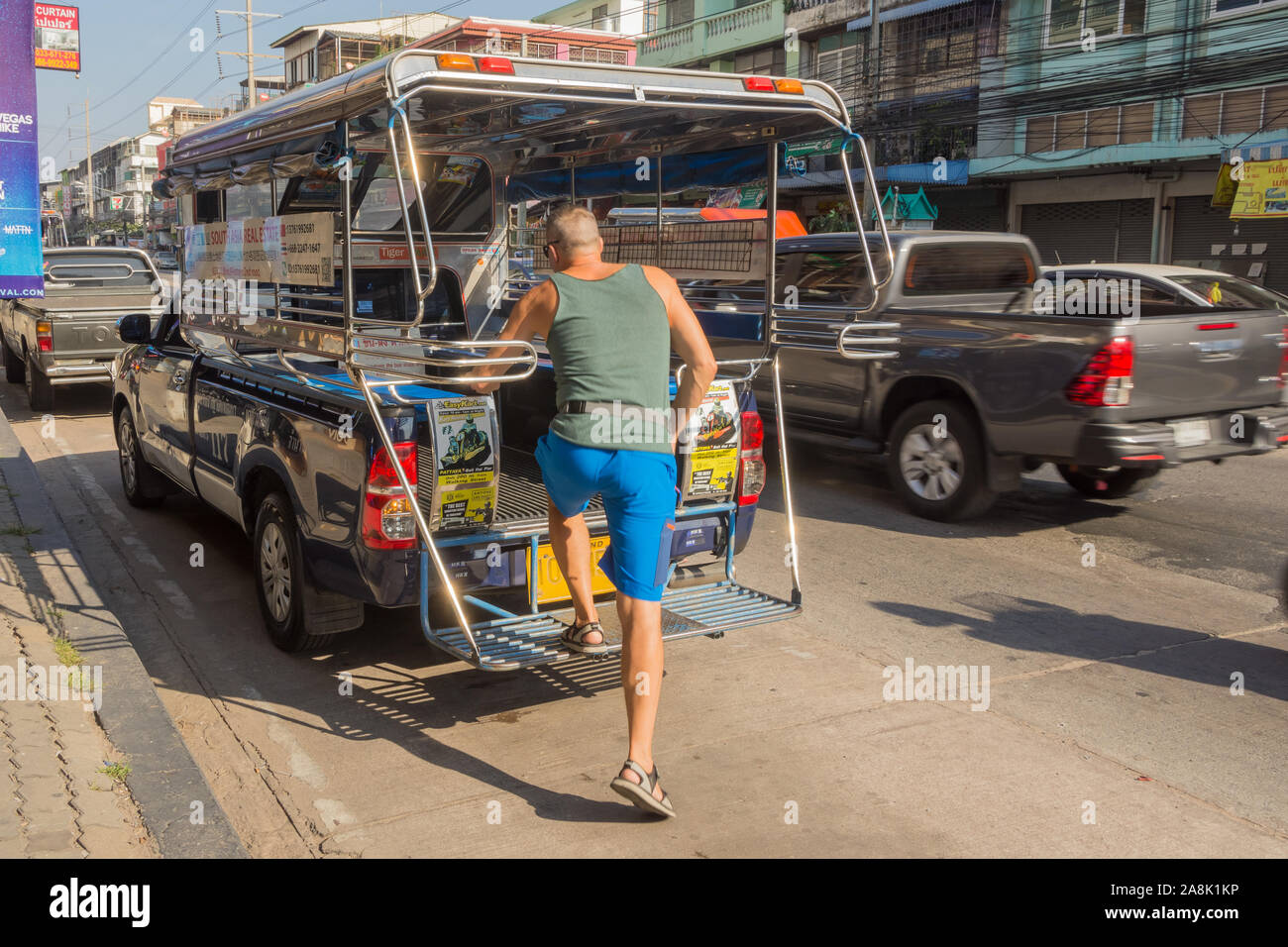 passenger climbs on asongthaew, a pickup truck taxi, in Thailand Stock ...