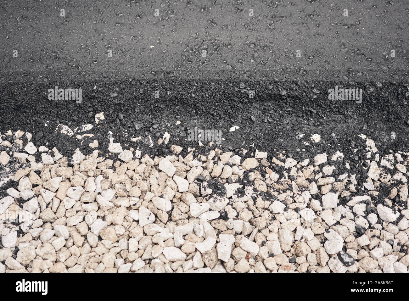 Closeup new hot asphalt. Laying asphalt, covering the pit, on the ...