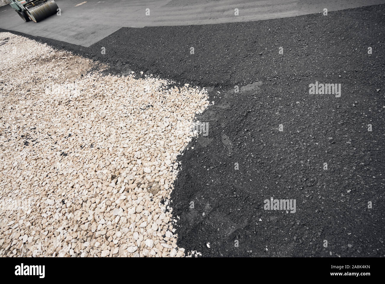 Closeup new hot asphalt. Laying asphalt, covering the pit, on the ...