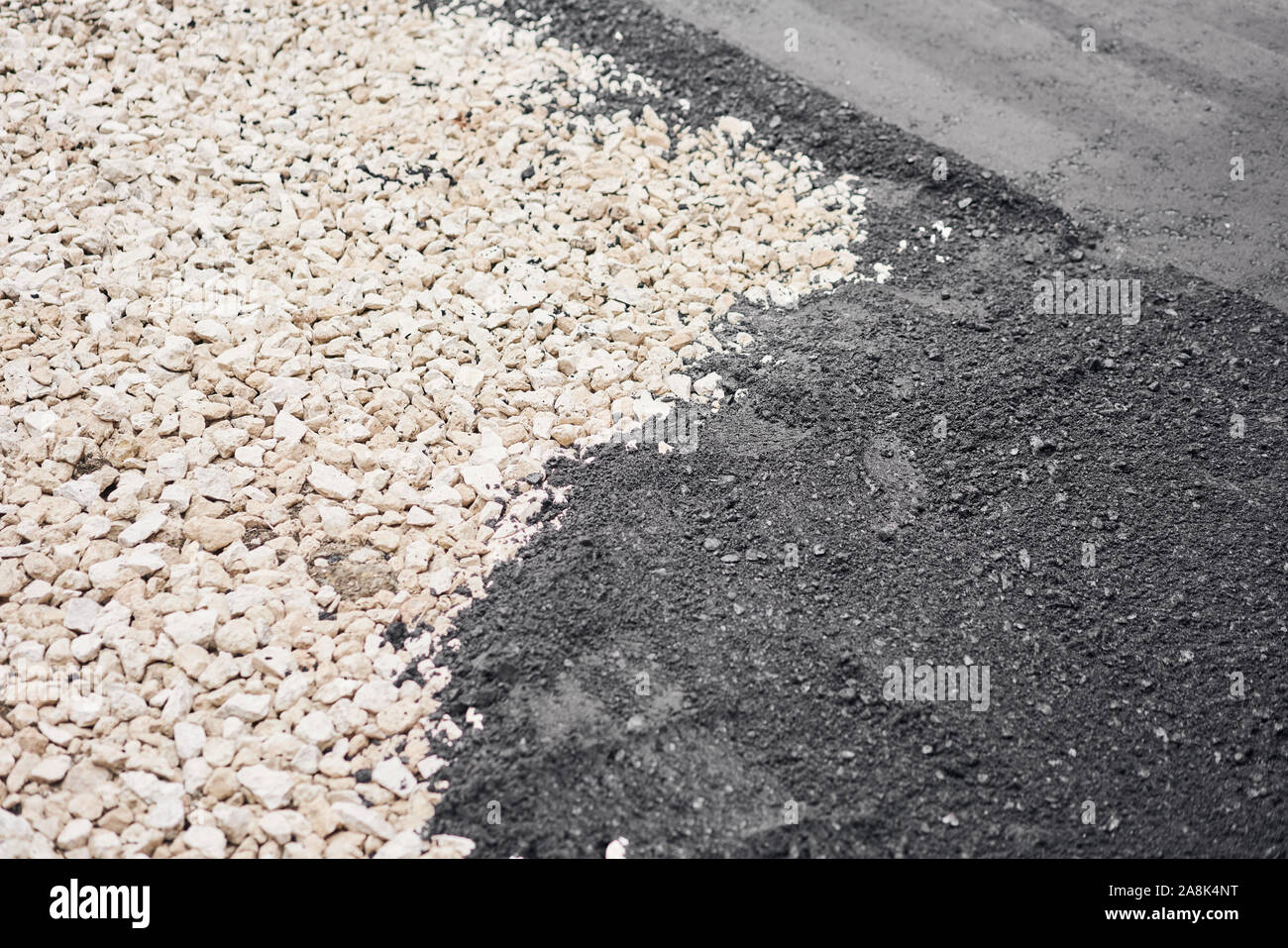 Closeup new hot asphalt. Laying asphalt, covering the pit, on the ...