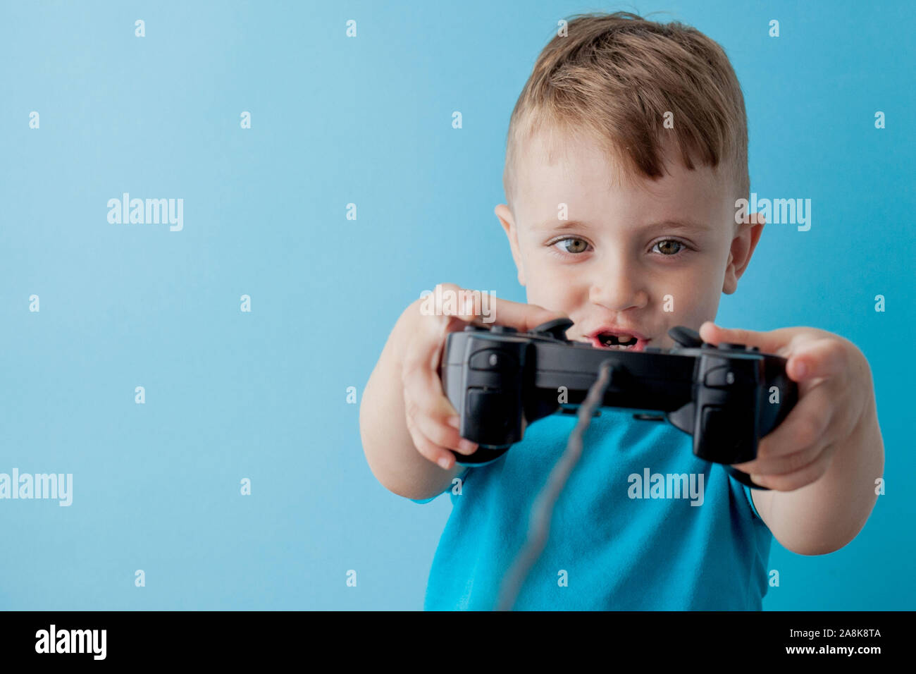 Little kid boy 2-3 years old wearing blue clothes hold in hand joystick ...