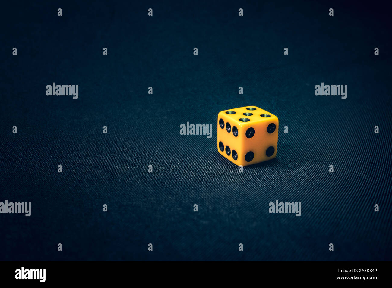 6 sided yellow die for a game on background Stock Photo - Alamy