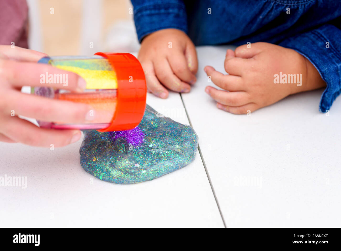 Process of making slime. Children playing with blue magic glitter slime ...
