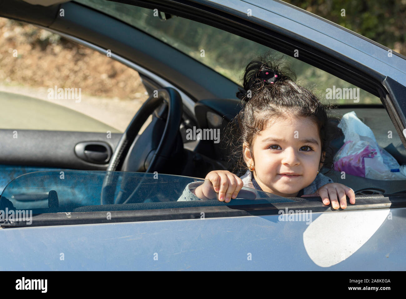 Little girl looking out the window of a car in outdoor area Stock Photo ...