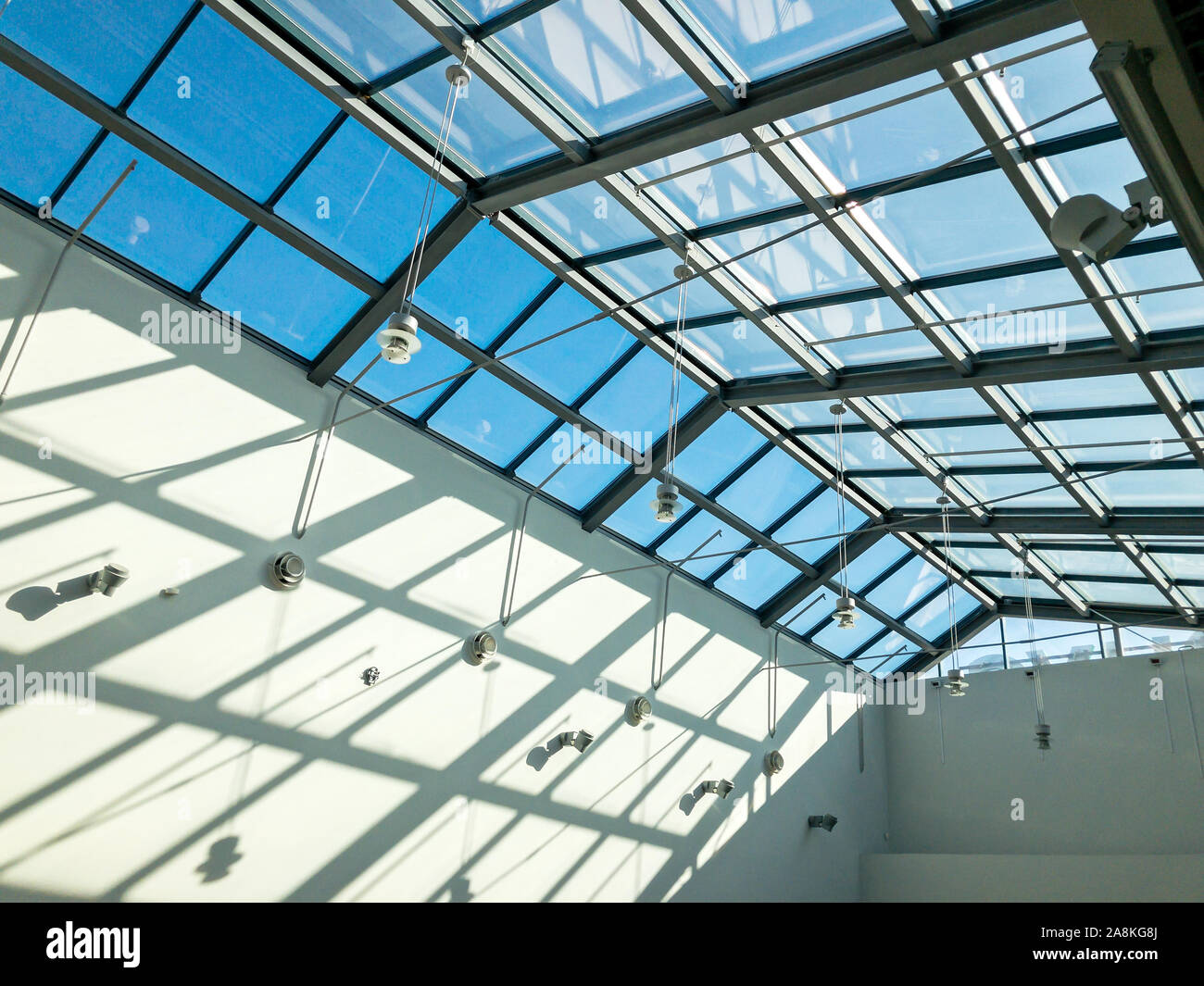 view from below the transparent glass roof of shopping mall at sunny ...