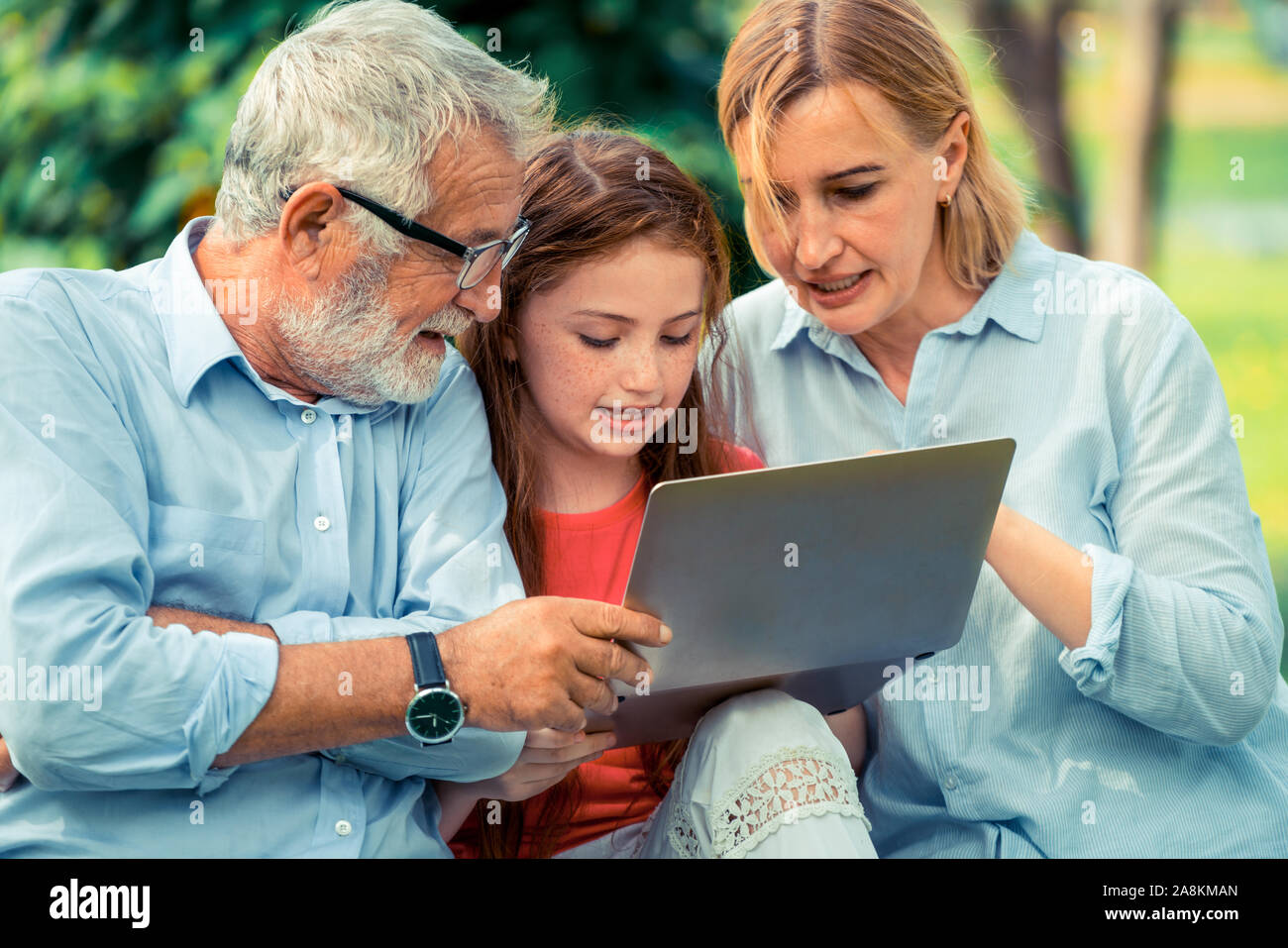 Happy family using laptop computer together in the garden park in ...