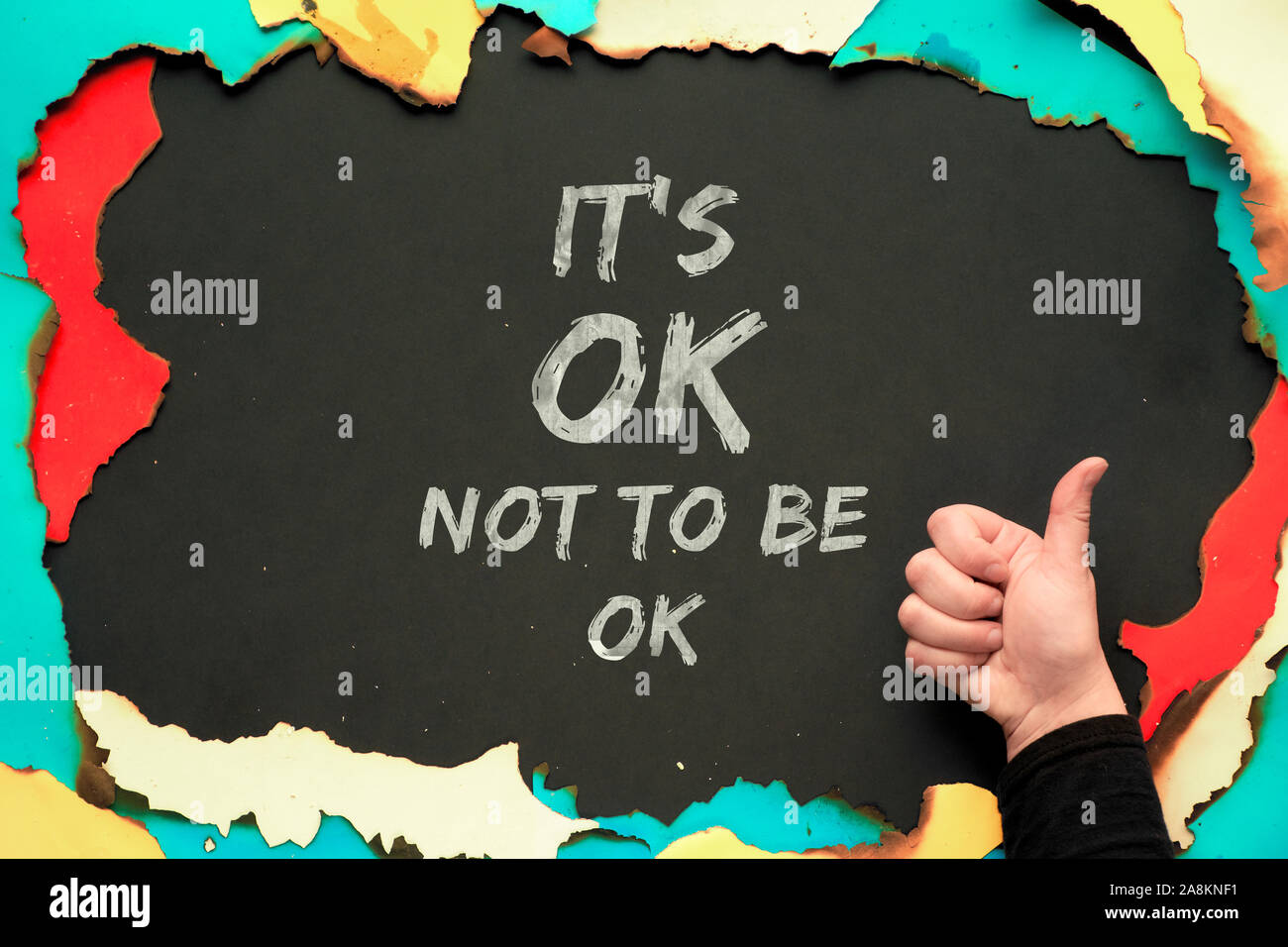 Text "It's OK not to be OK " in burnt paper frame on black background ...