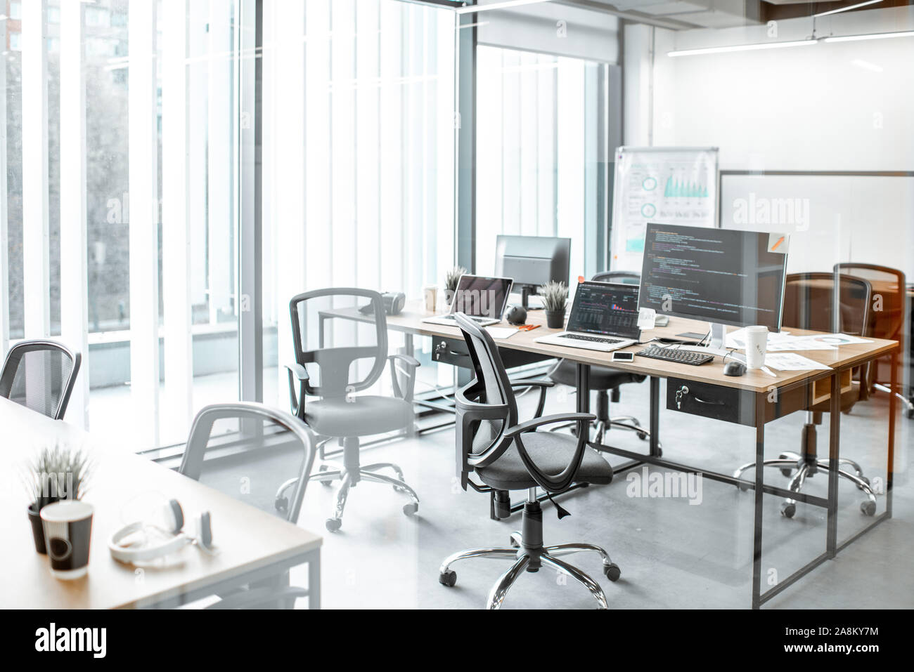 Working places with computers, gadgets and some documents on the table ...