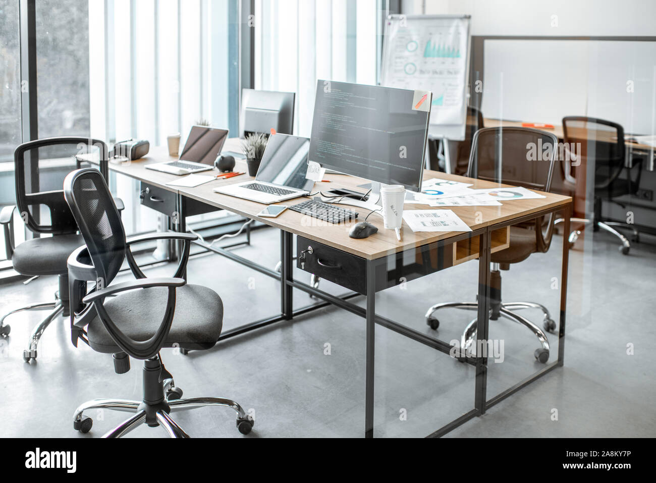 Working places with computers, gadgets and some documents on the table ...