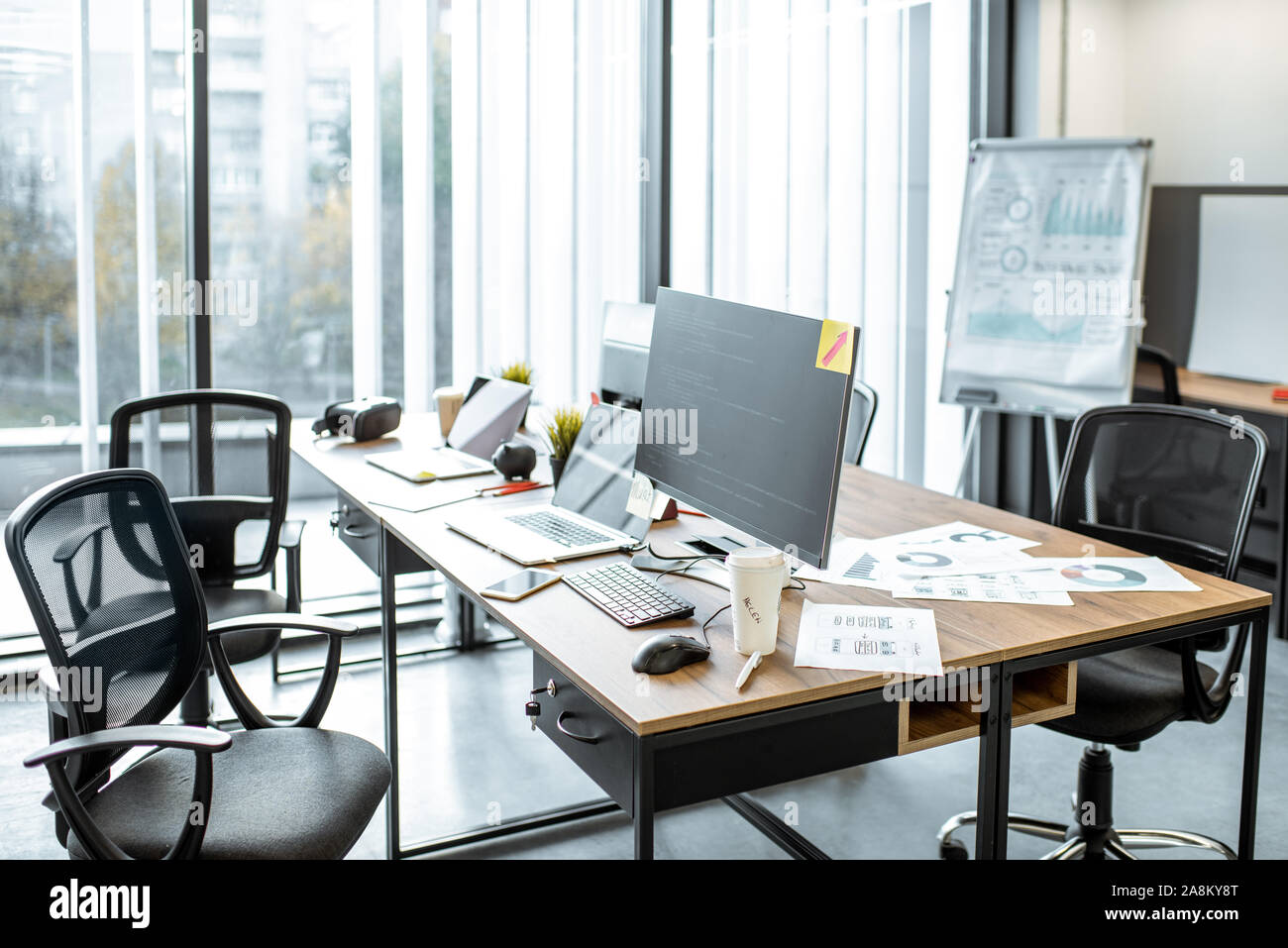 Working places with computers, gadgets and some documents on the table ...