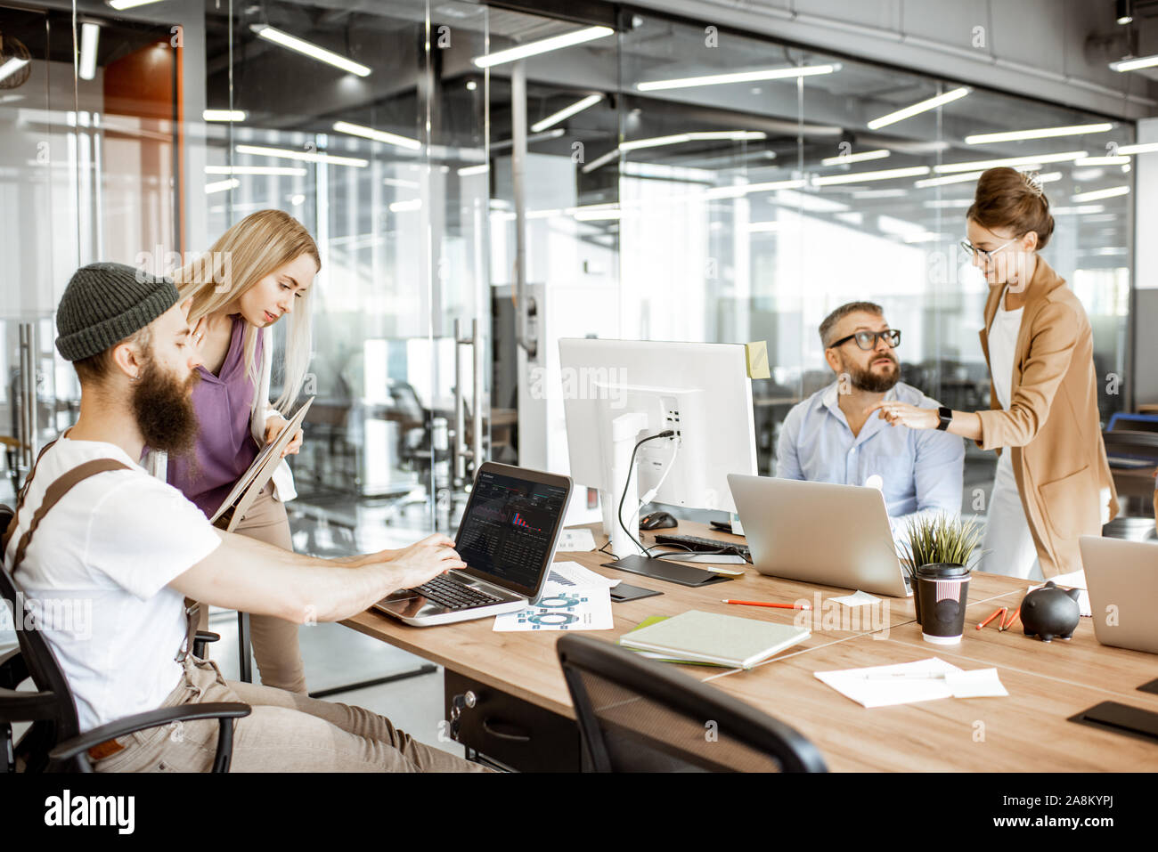 Group of diverse colleagues working on the computers in the modern ...