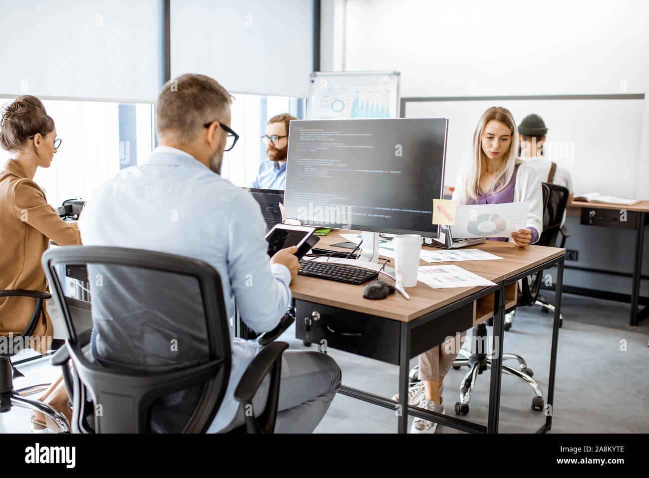 Group of diverse colleagues working on the computers in the modern ...