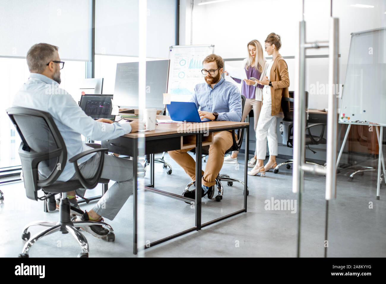 Group of diverse colleagues working on the computers in the modern ...