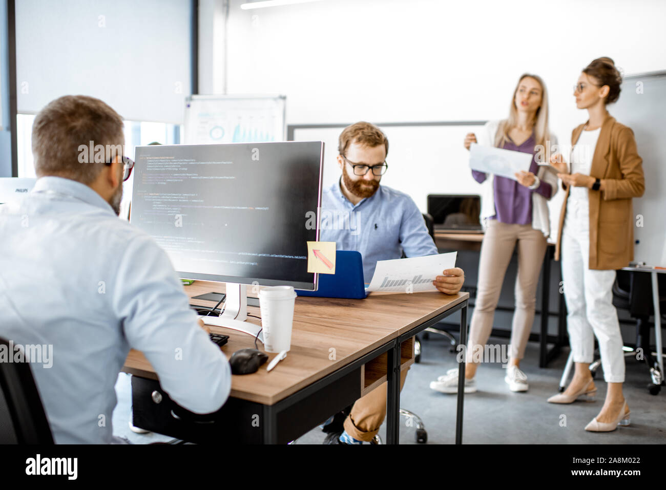 Group of diverse colleagues working on the computers in the modern ...