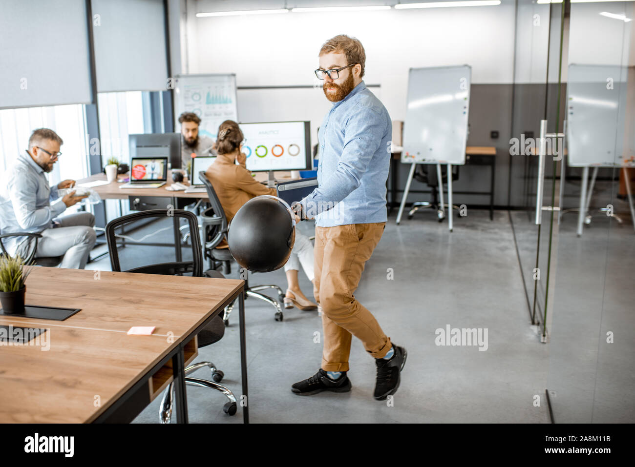 People working in the office, young man walks into the office with a ...