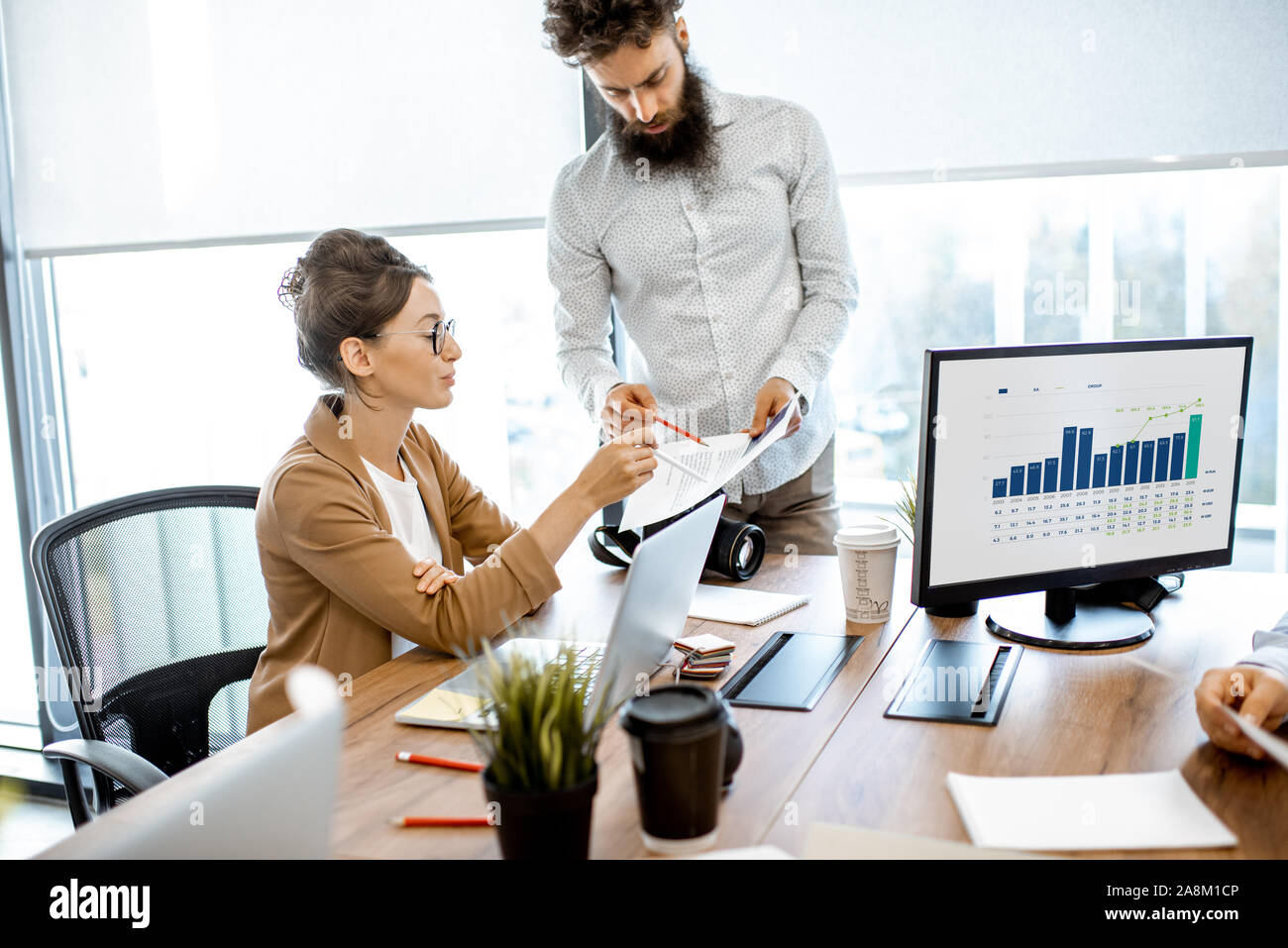 Two young colleagues talking at the working place, solving some working ...