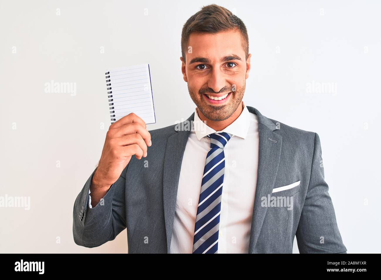 Young handsome business man holding blank notebook over isolated ...