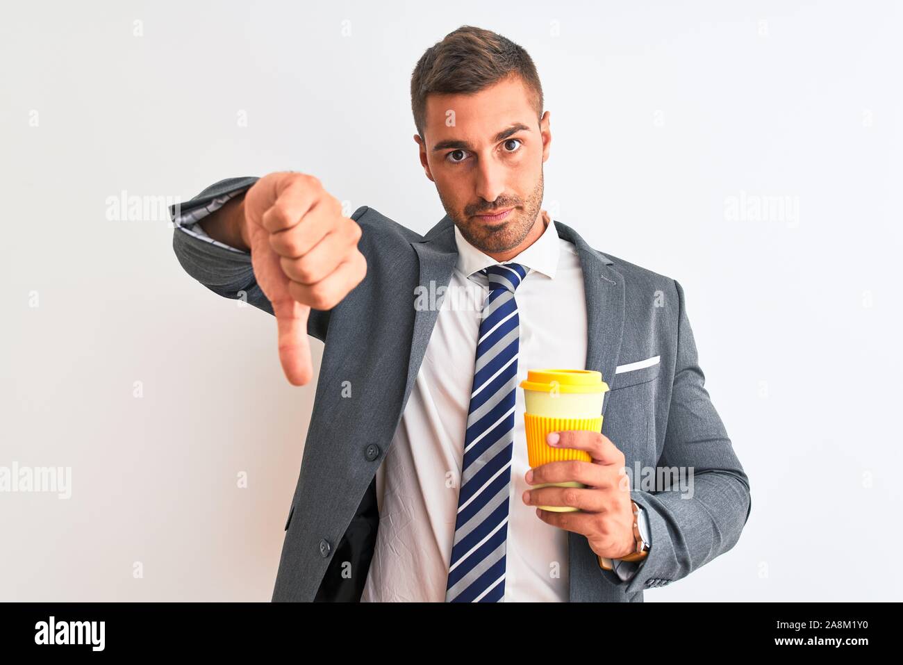 Young handsome business man drinking take away coffee over isolated ...