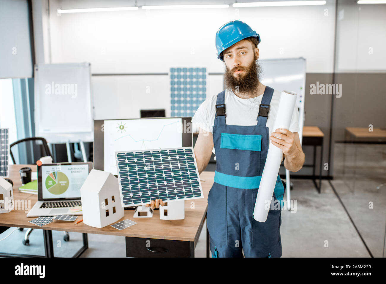 Portrait of a dedicated worker in workwear with blueprints and solar ...