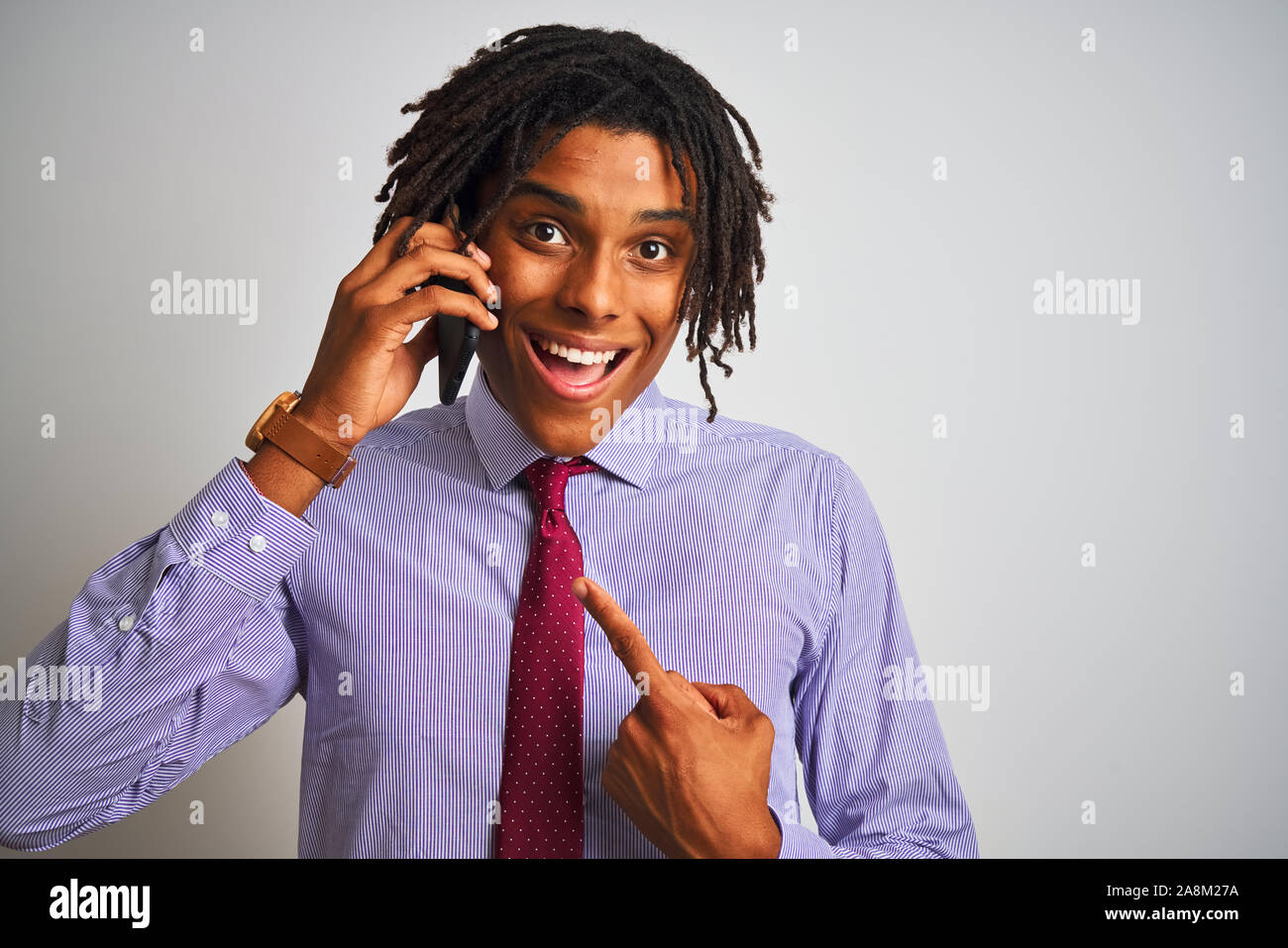 Afro businessman with dreadlocks talking using smartphone over isolated ...