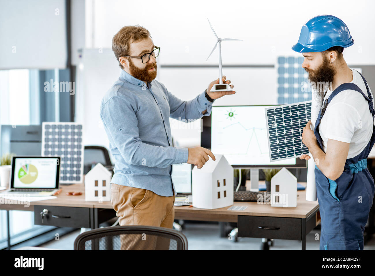 Young engineers and workman working on a project of alternative energy ...