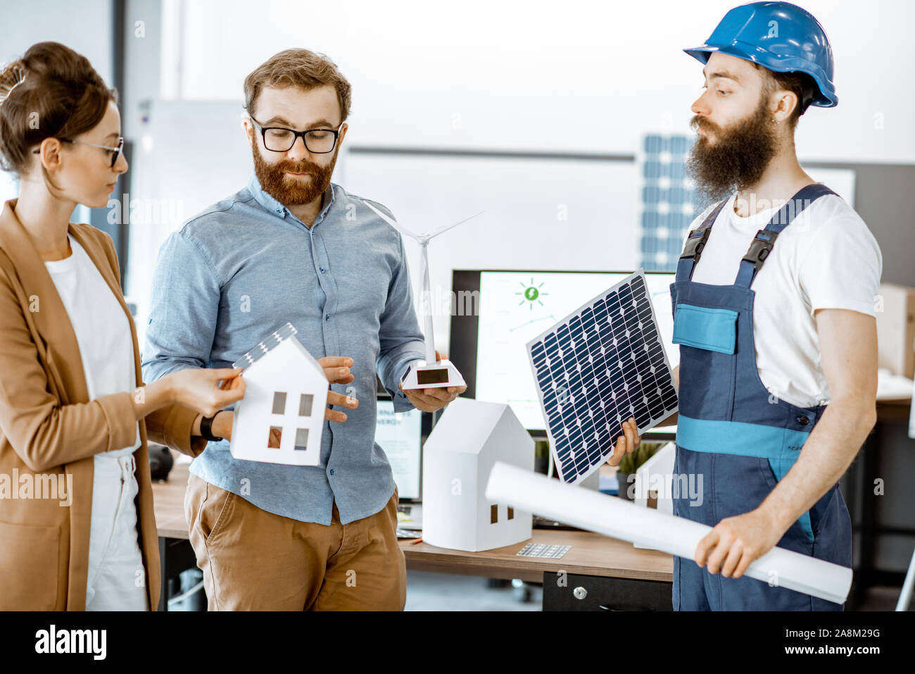 Young engineers and workman working on a project of alternative energy ...