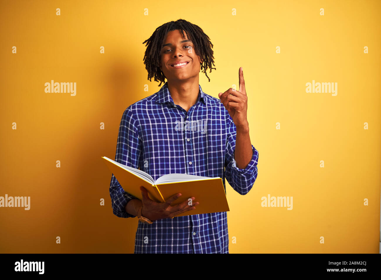 Afro american student man with dreadlocks reading book over isolated ...