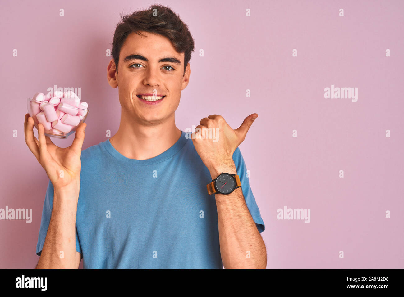 Teenager boy holding a bunch of delicious fluffy marshmallow over ...