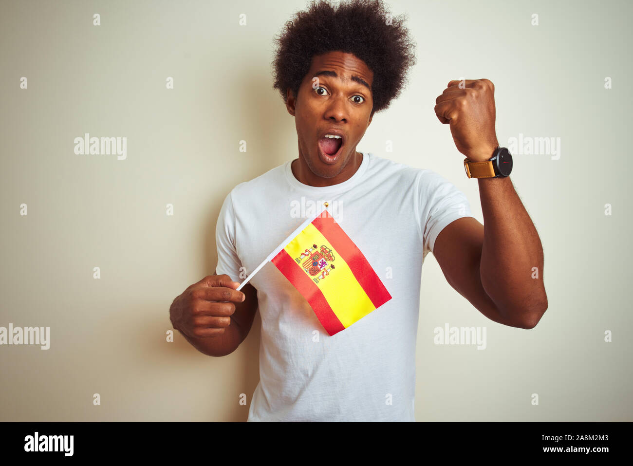 Young afro american man holding Spain Spanish flag standing over ...