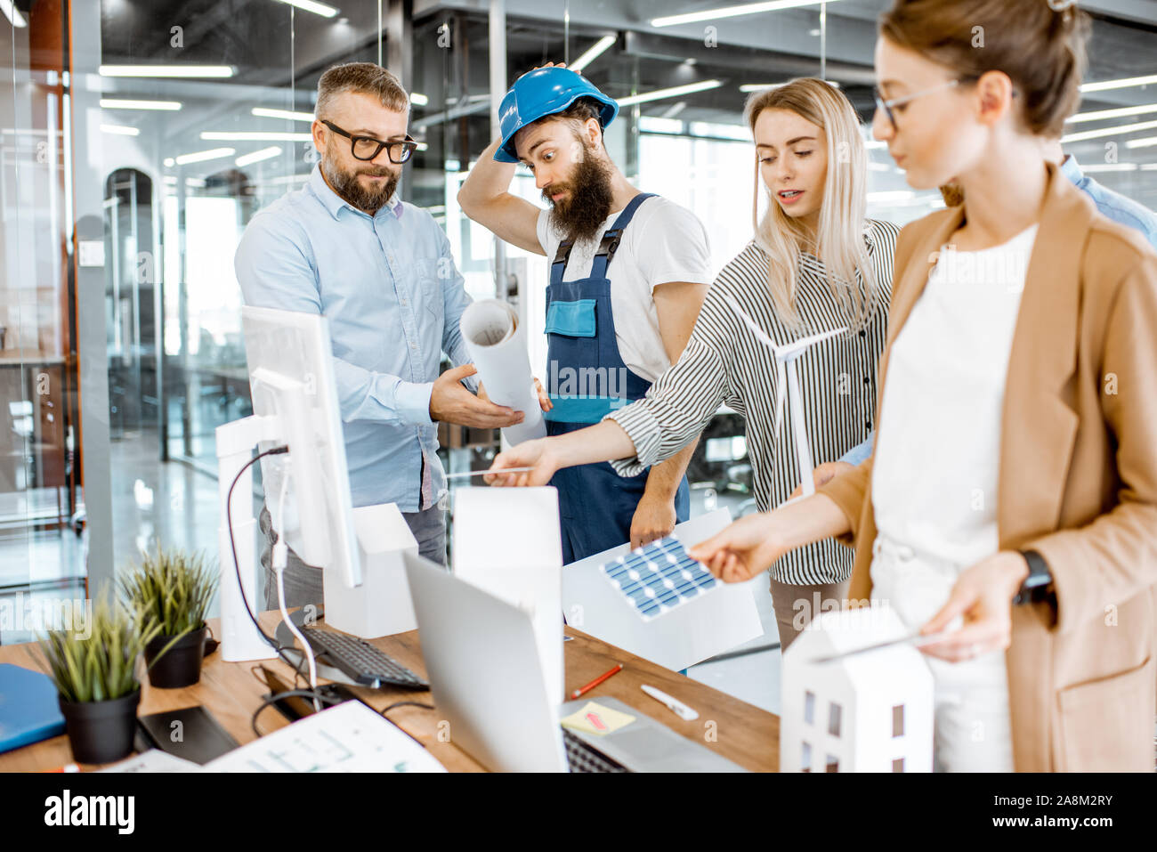 Group of engineers and workman working on a project of alternative ...