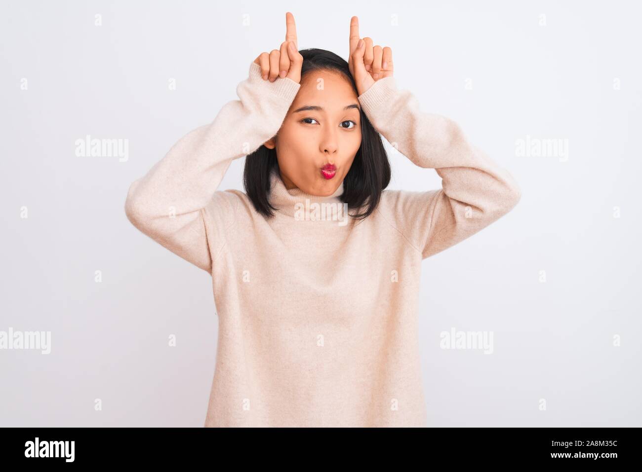 Young chinese woman wearing turtleneck sweater standing over isolated ...