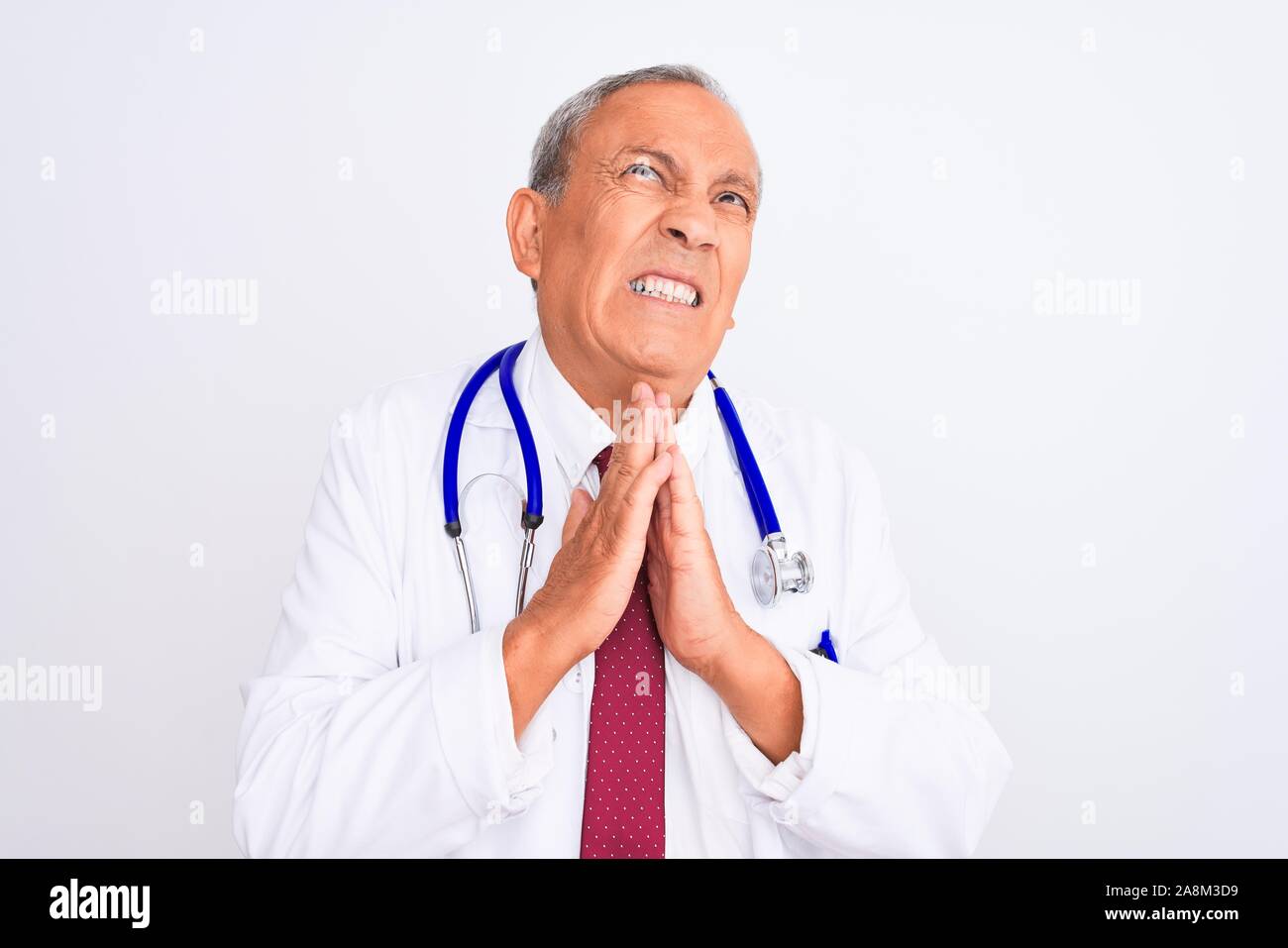 Senior grey-haired doctor man wearing stethoscope standing over ...