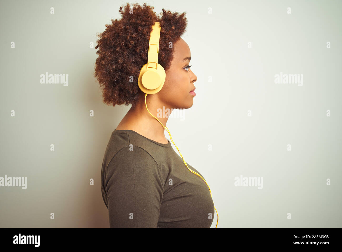 African american woman wearing headphones listening to music over ...