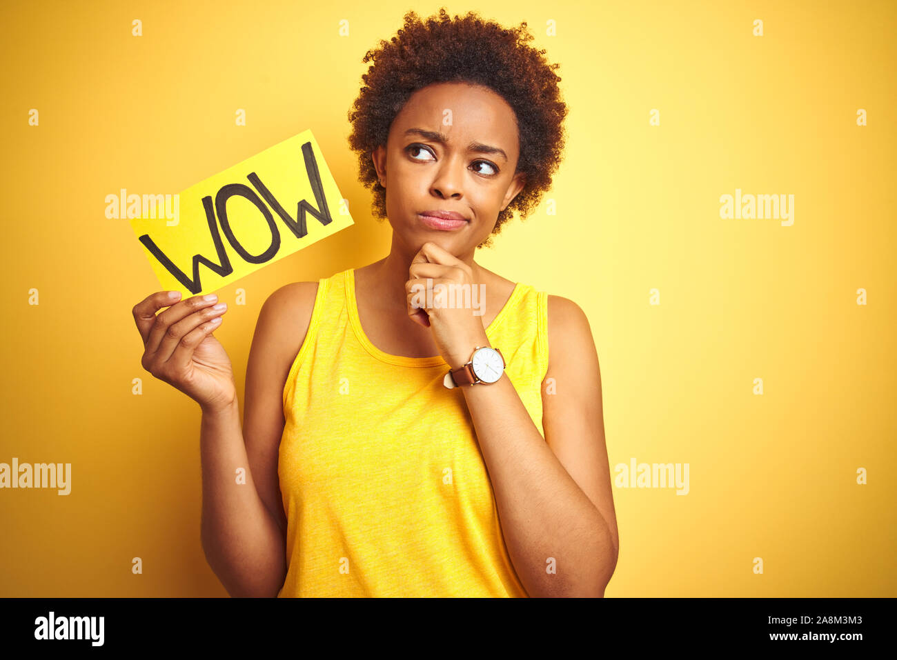 Young african american woman showing wow banner board over yellow ...