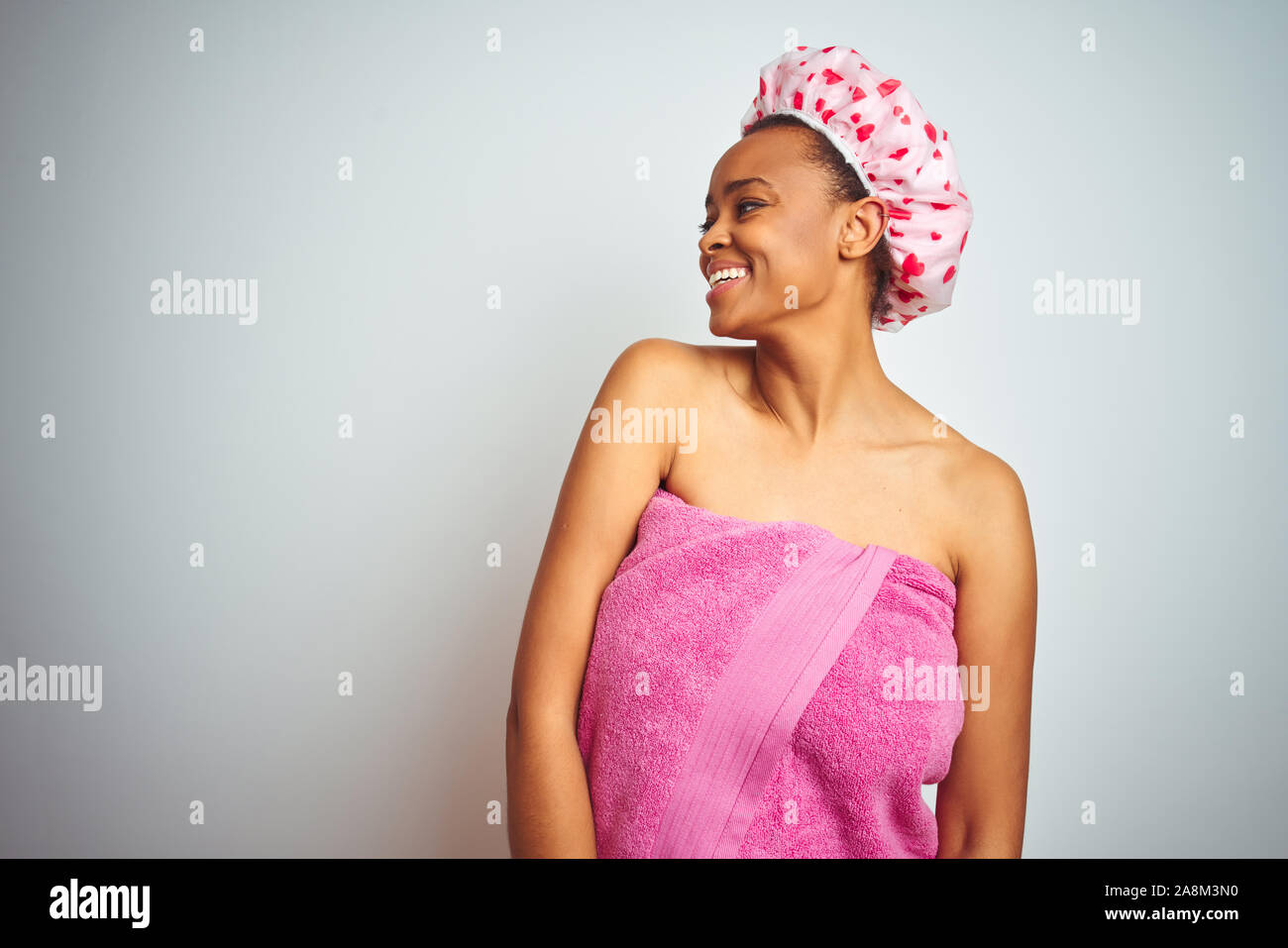 African american woman wearing pink shower towel after bath over ...