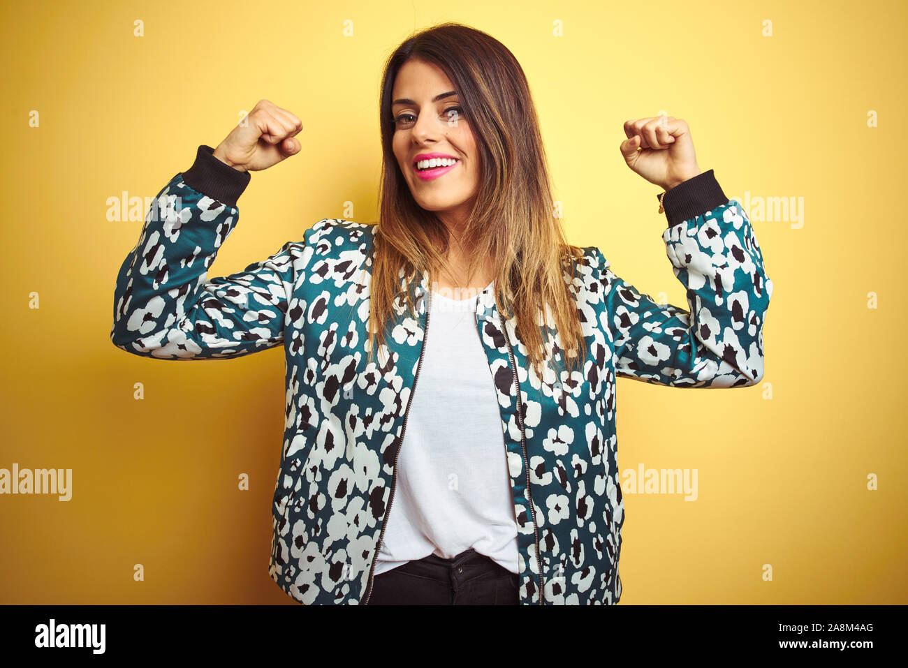 Young beautiful woman wearing casual jacket over yellow isolated ...
