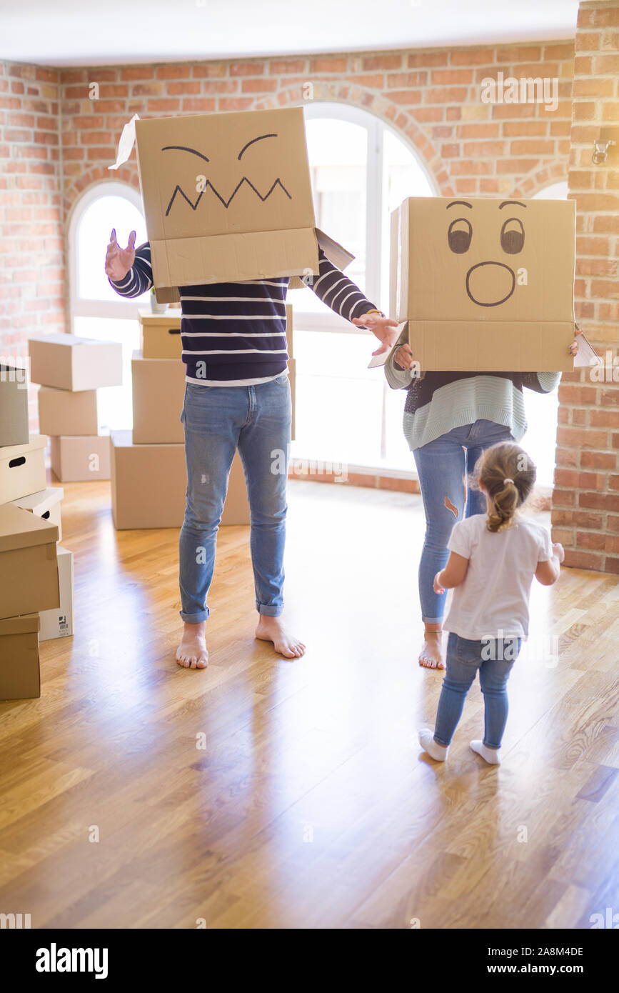 Beautiful famiily with kid playing with cardboard fanny boxes at new ...