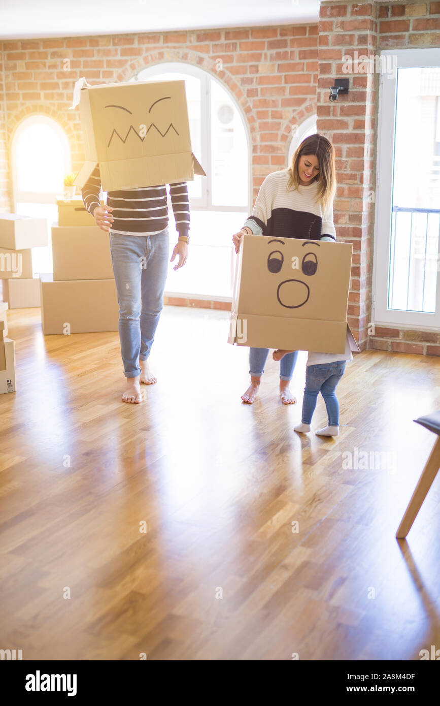 Beautiful famiily with kid playing with cardboard fanny boxes at new ...