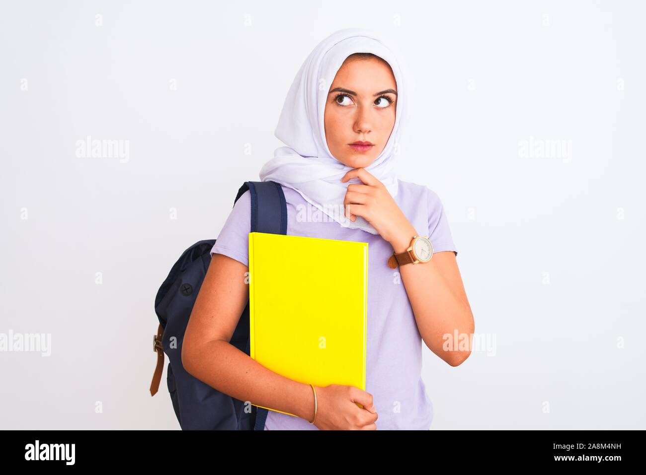 Arab student girl wearing hijab and backpack holding book over isolated ...